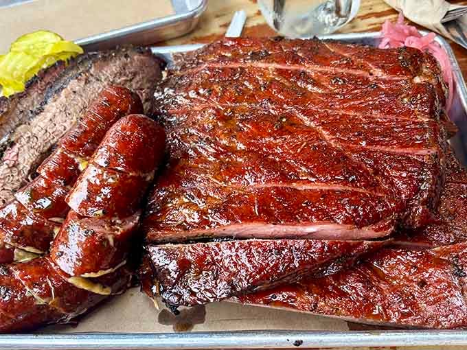 Ribs and sausage on a tray, glistening and smoky. This is what patience and wood fire look like together.