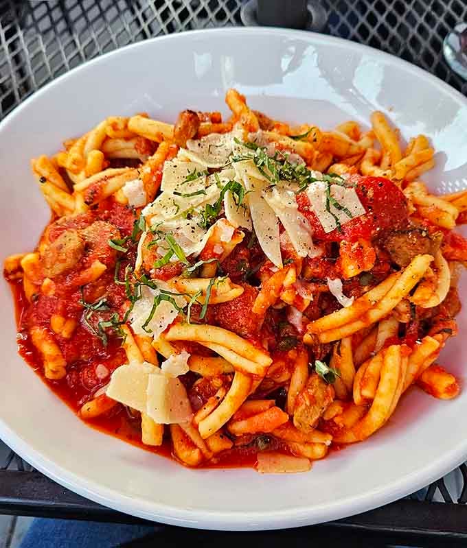 The Strozzapreti Calabrese arrives looking like a painting, spicy sausage, roasted peppers, and shaved parmigiano piled high and proud.