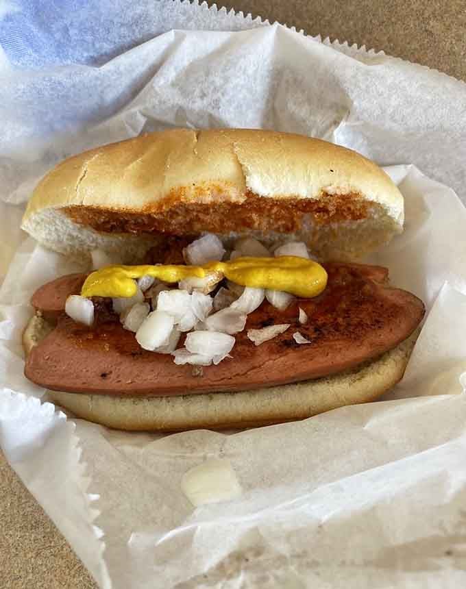 Mustard, onions, and a perfectly grilled frank&mdash;simplicity executed so well it borders on poetry in a bun.
