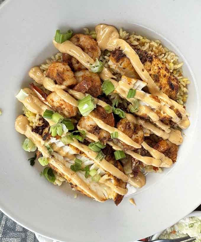 Cajun-spiced perfection drizzled with sauce and topped with green onions; your taste buds just won the lottery.