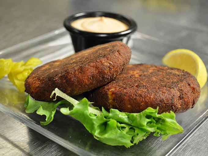 Two golden crab cakes, perfectly crusted, served with a house sauce that locals simply refuse to share.