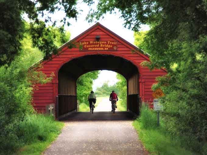 Two cyclists disappear into the bridge like they've found a portal to somewhere wonderful.
