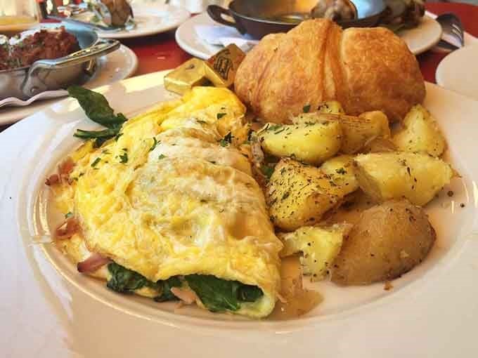 Behold the omelet that launched a thousand return visits, fluffy perfection with roasted potatoes and a croissant.