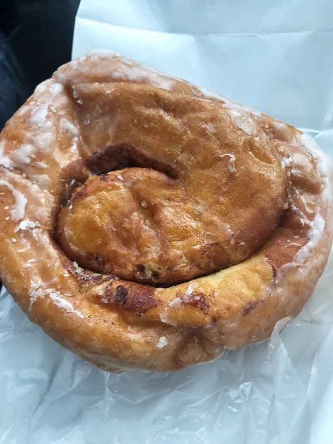 One glazed cinnamon roll, golden and glistening, proof that some things in life are genuinely perfect.