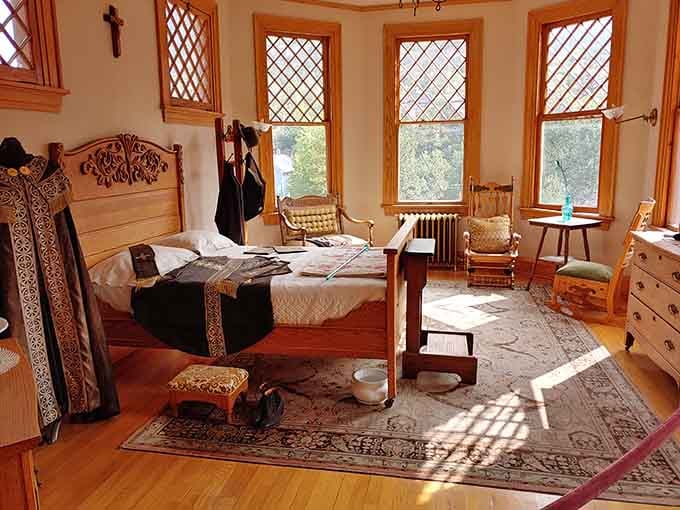 Sunlight pours through diamond-pane windows onto a bedroom that whispers stories of another century entirely.