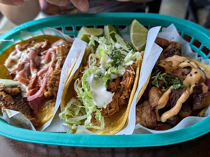 Three tacos in a basket, each dressed differently. This is the kind of lineup that makes decision-making genuinely difficult.