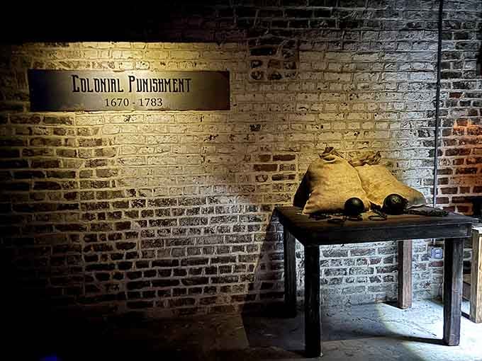 Colonial punishment artifacts sit quietly in the corner, reminding you this history is no joke.