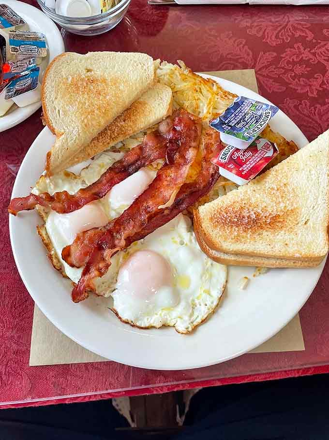 Two eggs, crispy bacon, golden toast, and hashbrowns on one plate. This is breakfast doing exactly what breakfast should do.