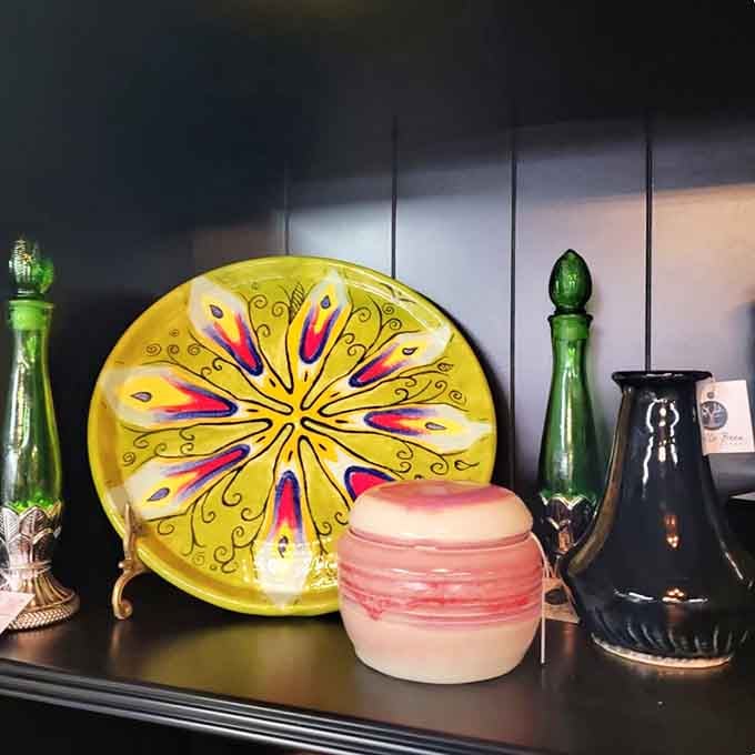 Every piece on this shelf has a story to tell, and that cheerful yellow plate is clearly the loudest storyteller in the room.