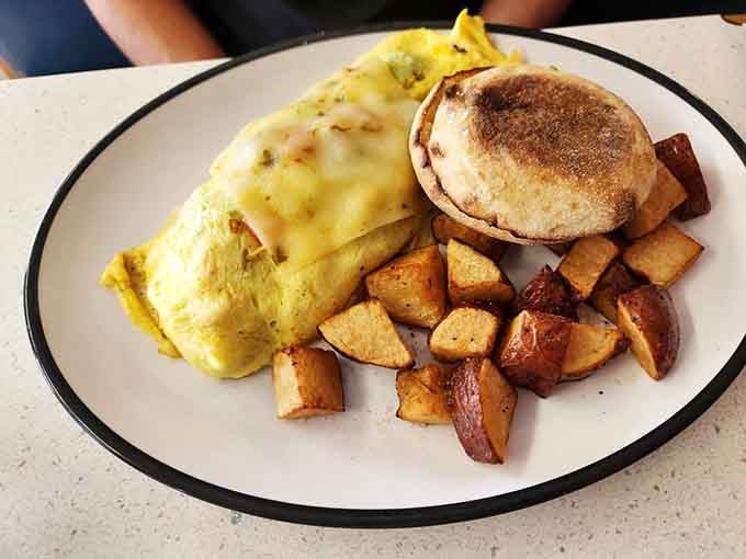 A fluffy omelet that proves eggs can be both art and comfort food, served with perfectly golden hash browns.