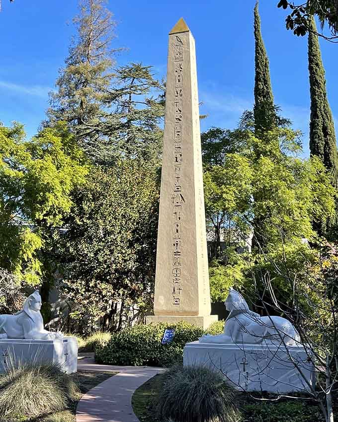 A full-scale obelisk covered in hieroglyphics, standing tall in a California garden, flanked by sphinx statues keeping quiet watch.