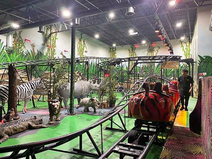 A mini roller coaster winding past rhinos, zebras, and crocodiles, because why not raise the bar completely.