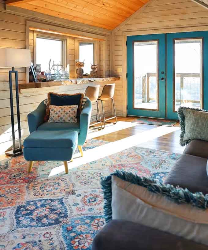 Teal chairs, colorful rugs, and a live-edge bar counter. This treehouse has better taste than most apartments.