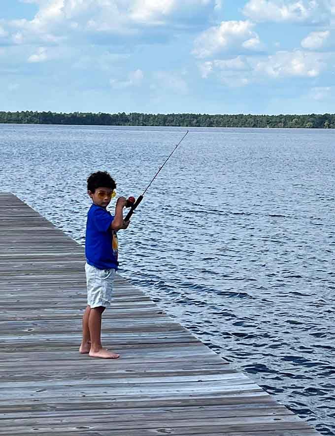 Barefoot, sunglasses on, fishing rod in hand. This kid already understands something most adults spend years trying to figure out.