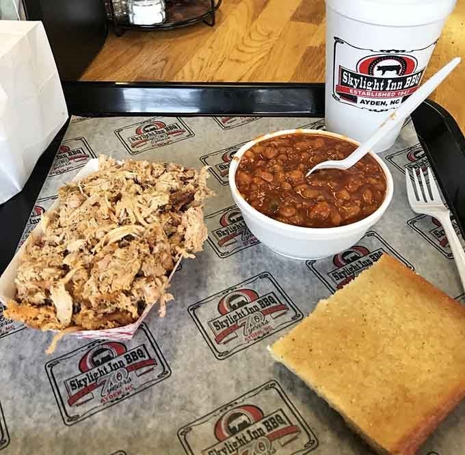 Smoky, hand-chopped whole hog pork with baked beans and cornbread &mdash; this tray is pure eastern North Carolina on a plate.