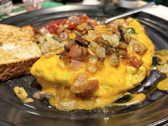 Melted cheddar cascading over a loaded omelette with golden toast alongside. Saturday mornings just got an upgrade.