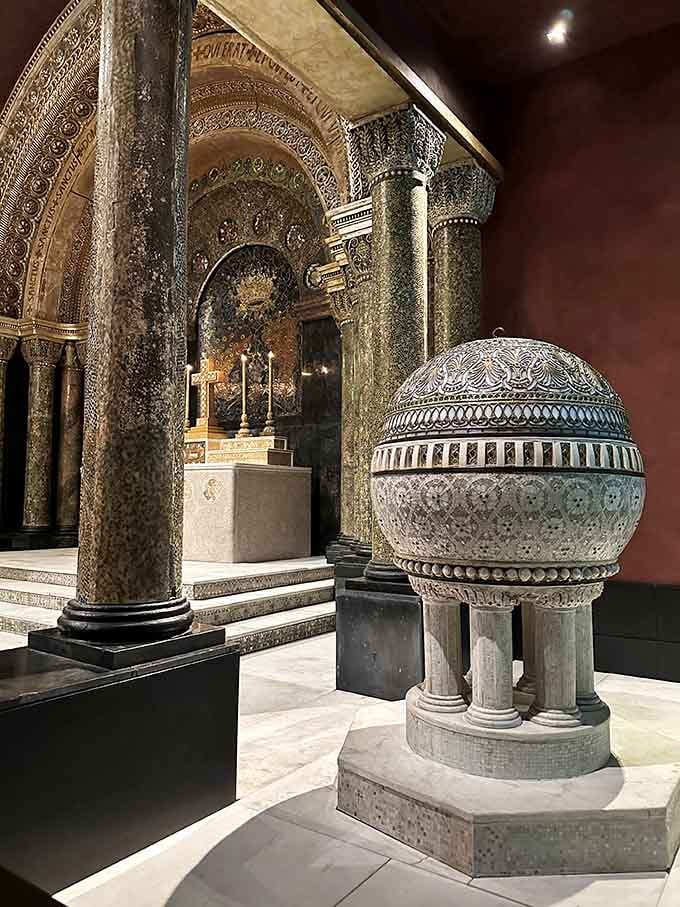 That mosaic-covered baptismal font sitting beside the chapel altar is the kind of detail that stops you mid-stride and demands your full attention.