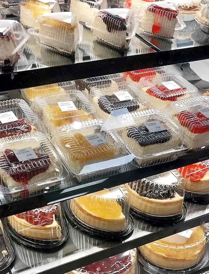 Cheesecake slices lined up like edible works of art. Cherry, blueberry, chocolate. The hardest decision you'll make all week.