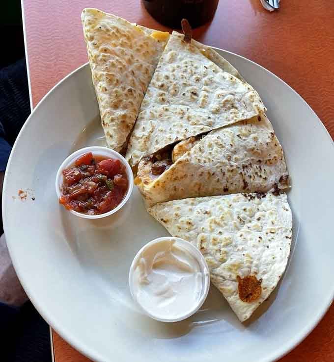 Crispy, golden, and served with salsa and sour cream, this quesadilla means serious business on a very cheerful plate.