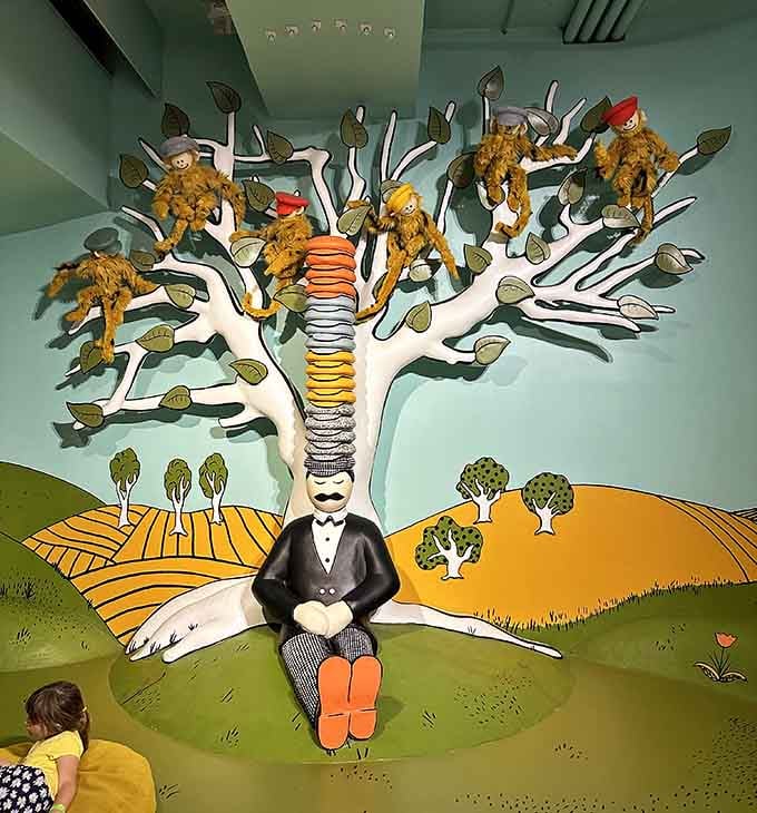 A man in a suit, a towering stack of hats, and monkeys in a tree — Caps for Sale never looked this good in real life.