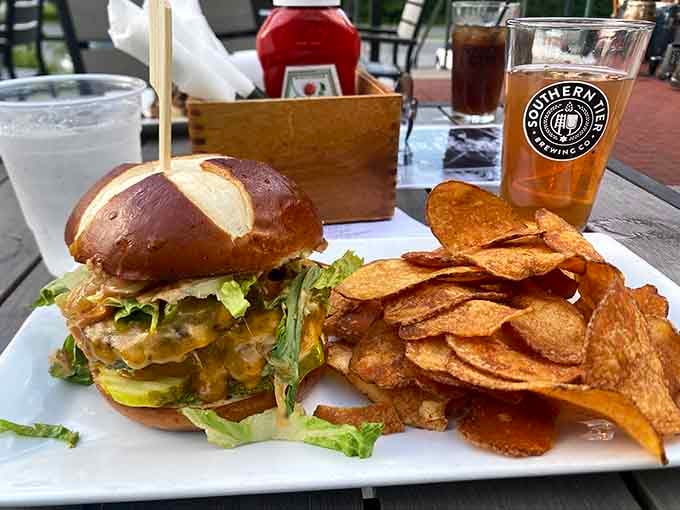 A burger so loaded and proud, it arrives wearing a pretzel bun like a crown. House chips included, no apologies necessary.