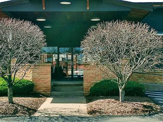 Welcoming entrance framed by trees that know how to dress up for dinner, even in their winter whites.