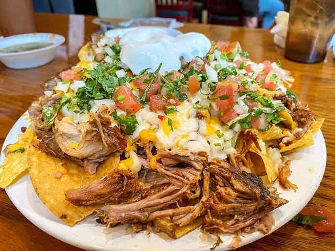 Carnitas nachos piled so high they could qualify as a geological formation, and every layer is worth exploring.