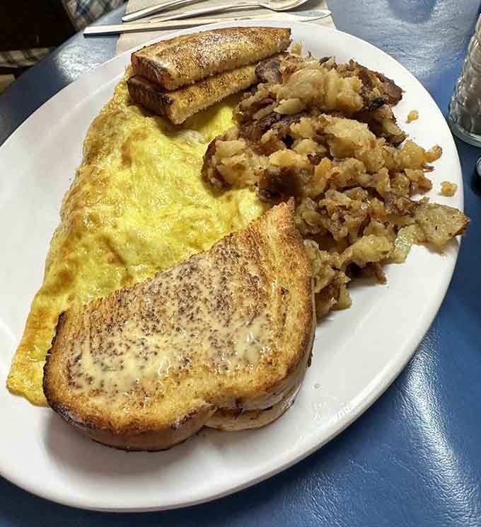 A golden omelette, crispy home fries, and buttered toast. This plate is the reason alarm clocks were invented.