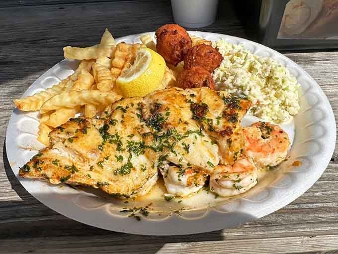 Grilled grouper and shrimp on one plate, with fries and hushpuppies alongside. Coastal Carolina at its finest.