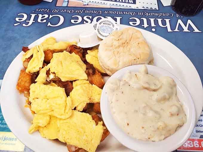 Scrambled eggs, crispy potatoes, a fluffy biscuit, and a bowl of gravy, this is what a good morning actually looks like.
