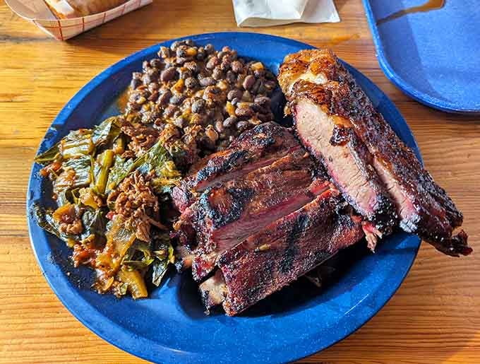 Ribs, brisket, collard greens, and beans on one plate. Someone here understands the assignment perfectly.