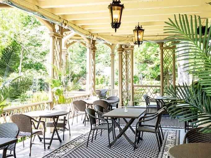 Wicker chairs, hanging lanterns, and garden views. This porch seating area is where afternoons go to become memories.
