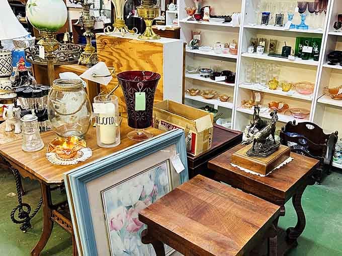 Antique lamps, ruby-red glassware, and framed artwork all sharing the same table, somehow making perfect sense together.