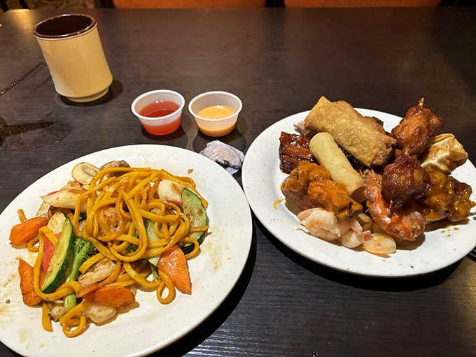 Two plates, zero regrets. Lo mein, spring rolls, sauced proteins, and shrimp all sharing one glorious table.