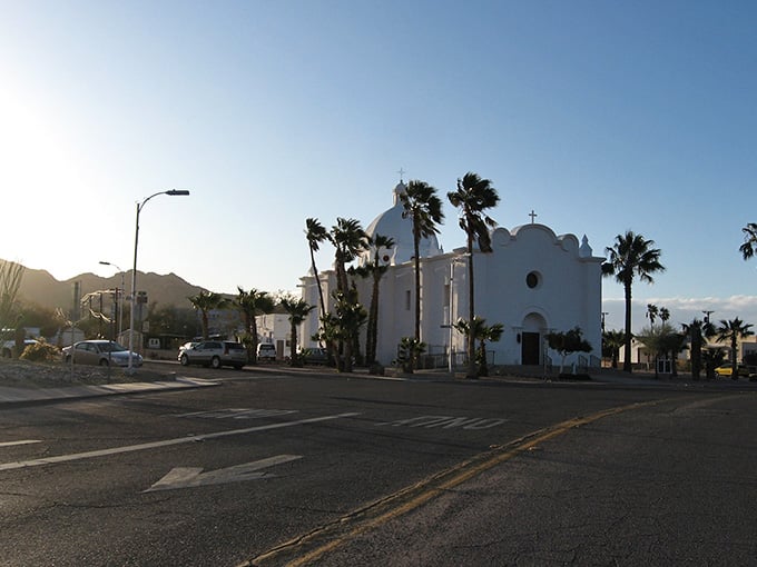 Golden desert light wraps around Ajo's white church at dusk, making the whole scene feel cinematic.