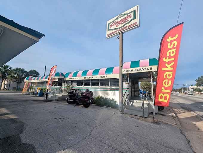 That pink, green, and white striped awning stretching along the vintage dining car is pure roadside poetry.