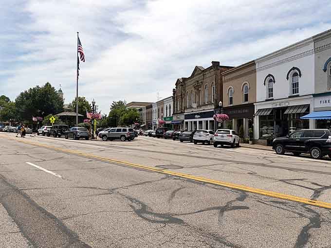 This main street stretches out under a summer sky, flags waving, storefronts gleaming, practically daring you not to stop and browse.