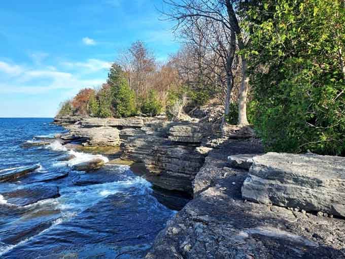 Ancient layered limestone meets crashing waves in a rugged shoreline scene that feels wild, dramatic, and completely unforgettable.