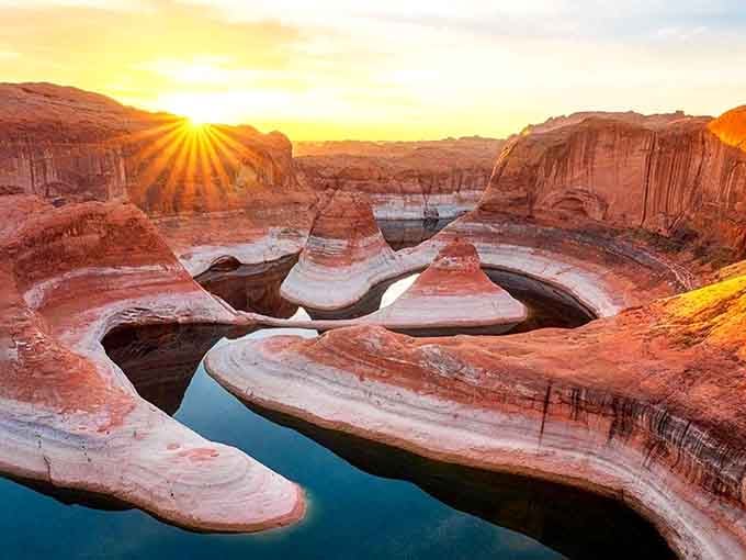 Lake Powell at sunrise looks like nature hired the world's greatest lighting director — and paid well.