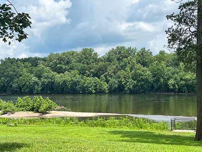 The Delaware River curving past a sandy bank and lush summer trees carries the quiet weight of American history.