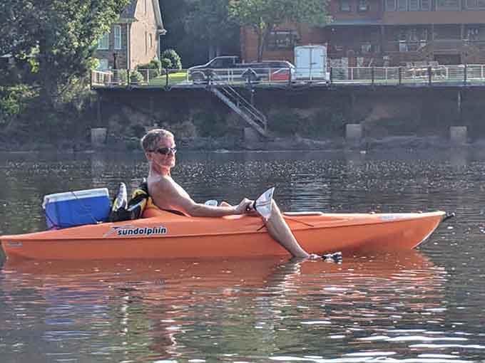 This kayaker has mastered the art of relaxation, complete with cooler and sunglasses for the ultimate river cruise.