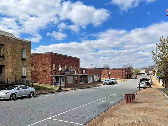 Cruising through history! A sleek silver car stands out beautifully against a backdrop of timeless, weathered brick storefronts.