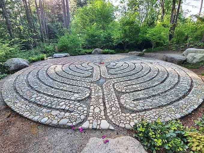 Intricate patterns of river rocks spiral inward, creating a meditative path that's part art, part spiritual journey.