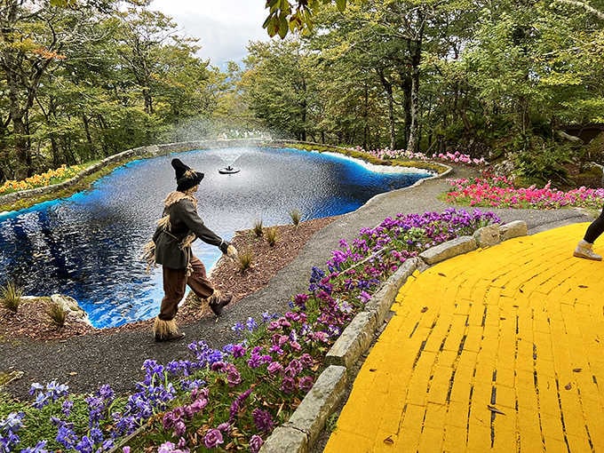 The Yellow Brick Road curves past a sparkling blue fountain and the Scarecrow himself, proving Oz found a home in North Carolina.