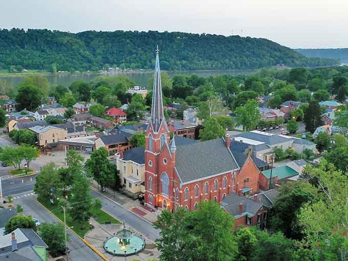 From above, the red brick church commands attention like a grand dame at Sunday service, surrounded by her devoted green congregation.