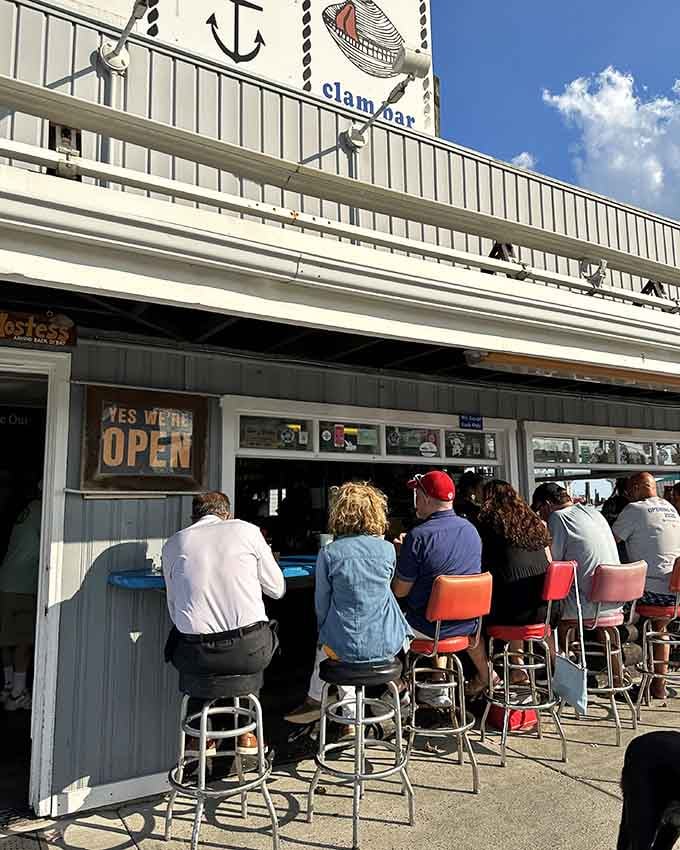 A row of happy people perched on red-and-chrome barstools under a bright blue sky &mdash; this is what a perfect afternoon looks like.