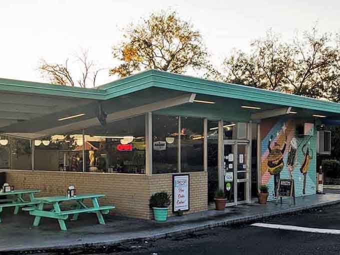 At golden hour, the mural-covered entrance and mint-green picnic tables make Sno-Cap look like a painting you want to eat inside.