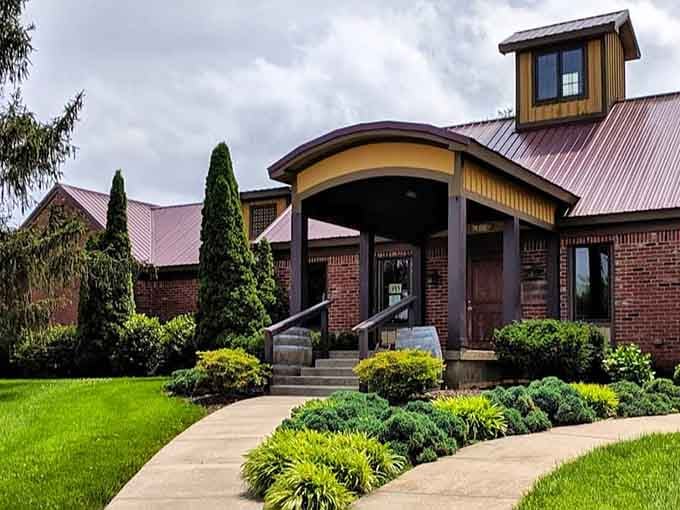 Tall evergreens stand like proud sentinels flanking the brick facade, as if guarding something truly worth discovering inside.