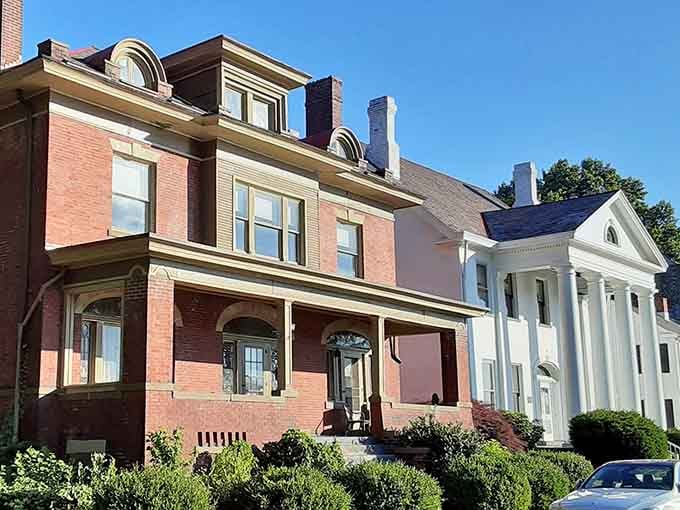 Side by side, a grand brick Victorian and a crisp Greek Revival home prove Wellsville's residential streets mean serious architectural business.
