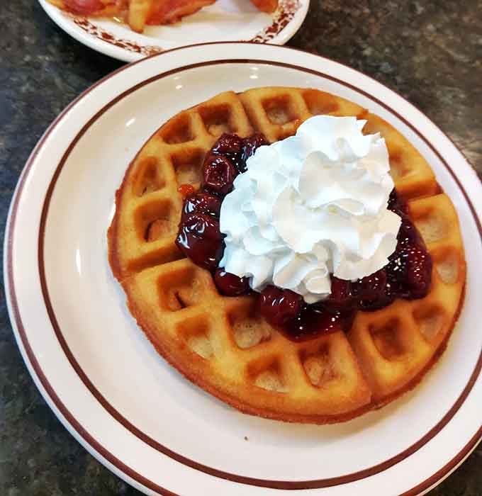 Golden, crispy, and crowned with cherries and whipped cream. This waffle just made your morning considerably better.